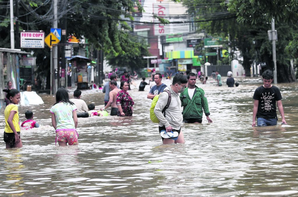 Thousands caught in floods in Indonesia’s sinking capital – Aruba Today
